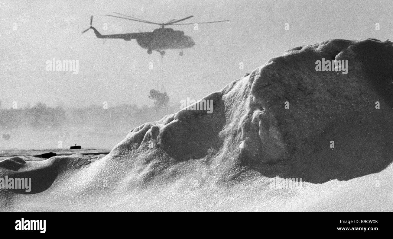 The helicopter is transporting an oil tank Stock Photo - Alamy
