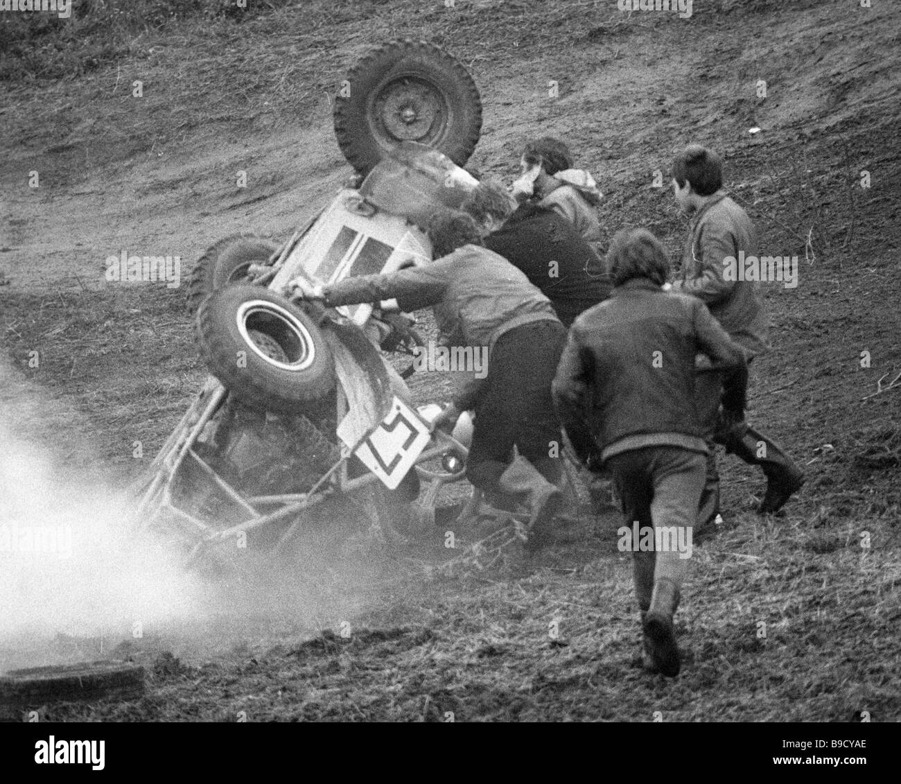 Racers raising their buggy overturned after the springboard failure ...