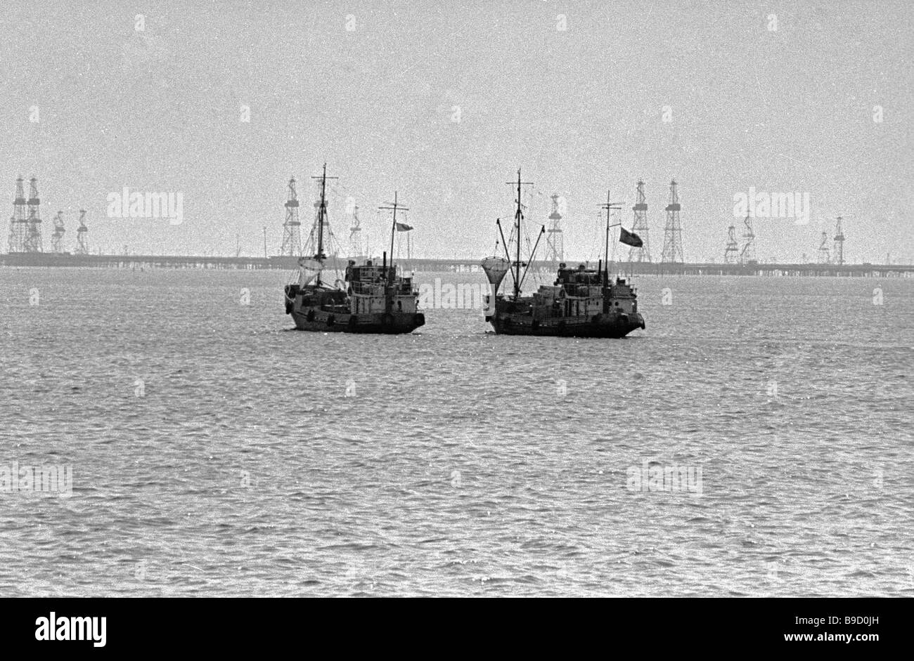 Seiners in the Caspian Sea Background oil derricks Stock Photo - Alamy
