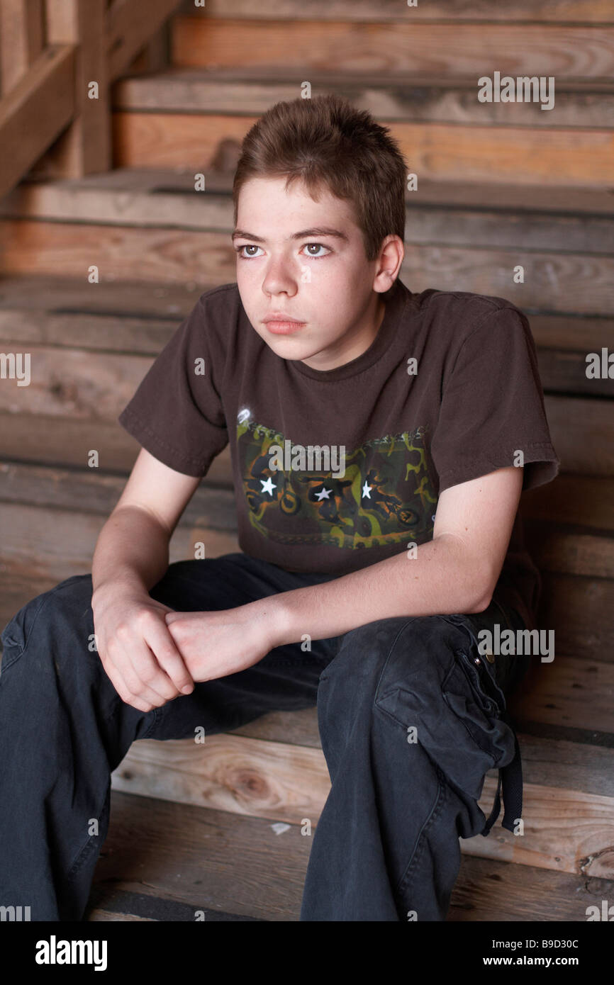 Young boy sitting on steps Stock Photo - Alamy