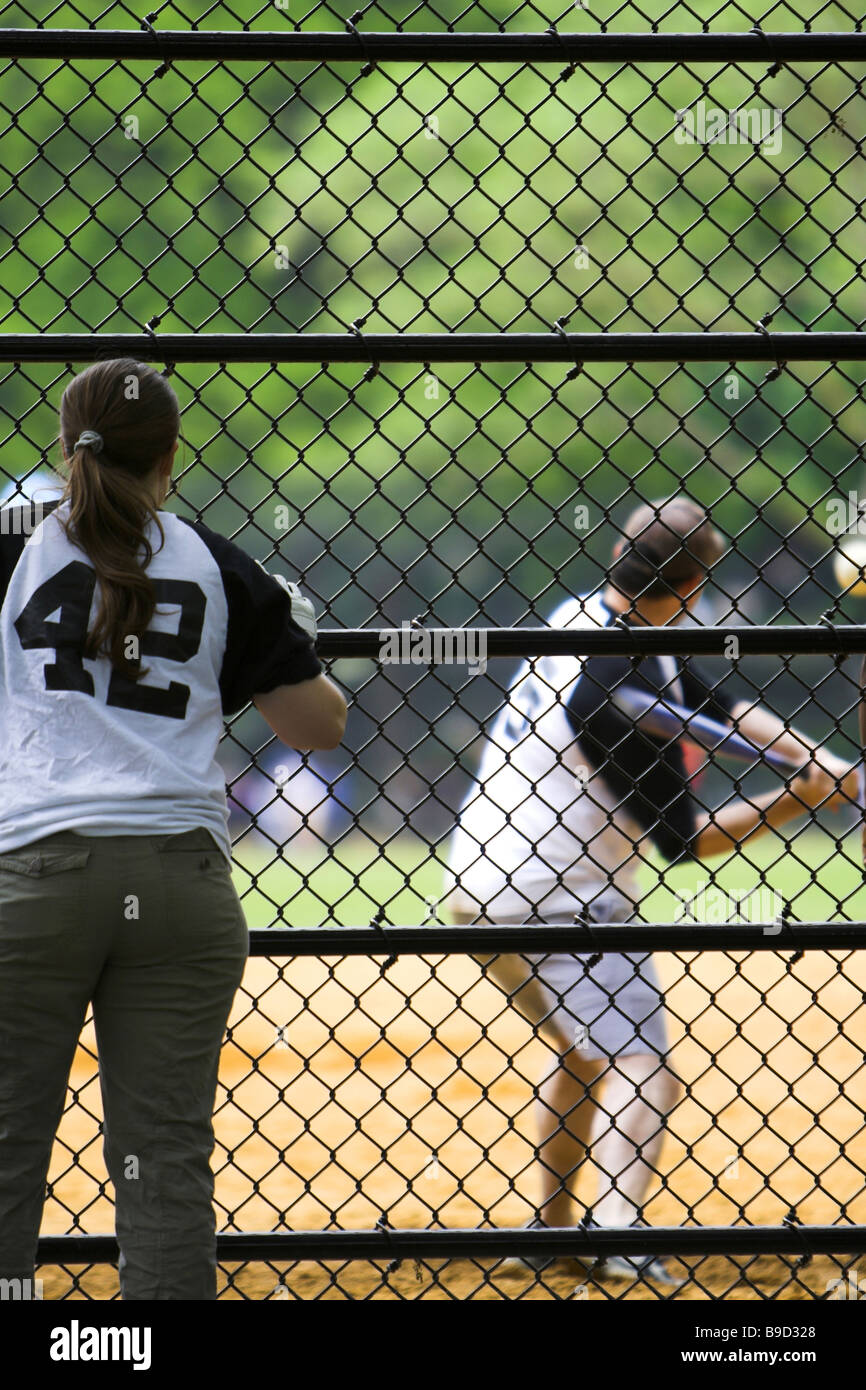 Girl watching and supporting a team mate play baseball Stock Photo - Alamy