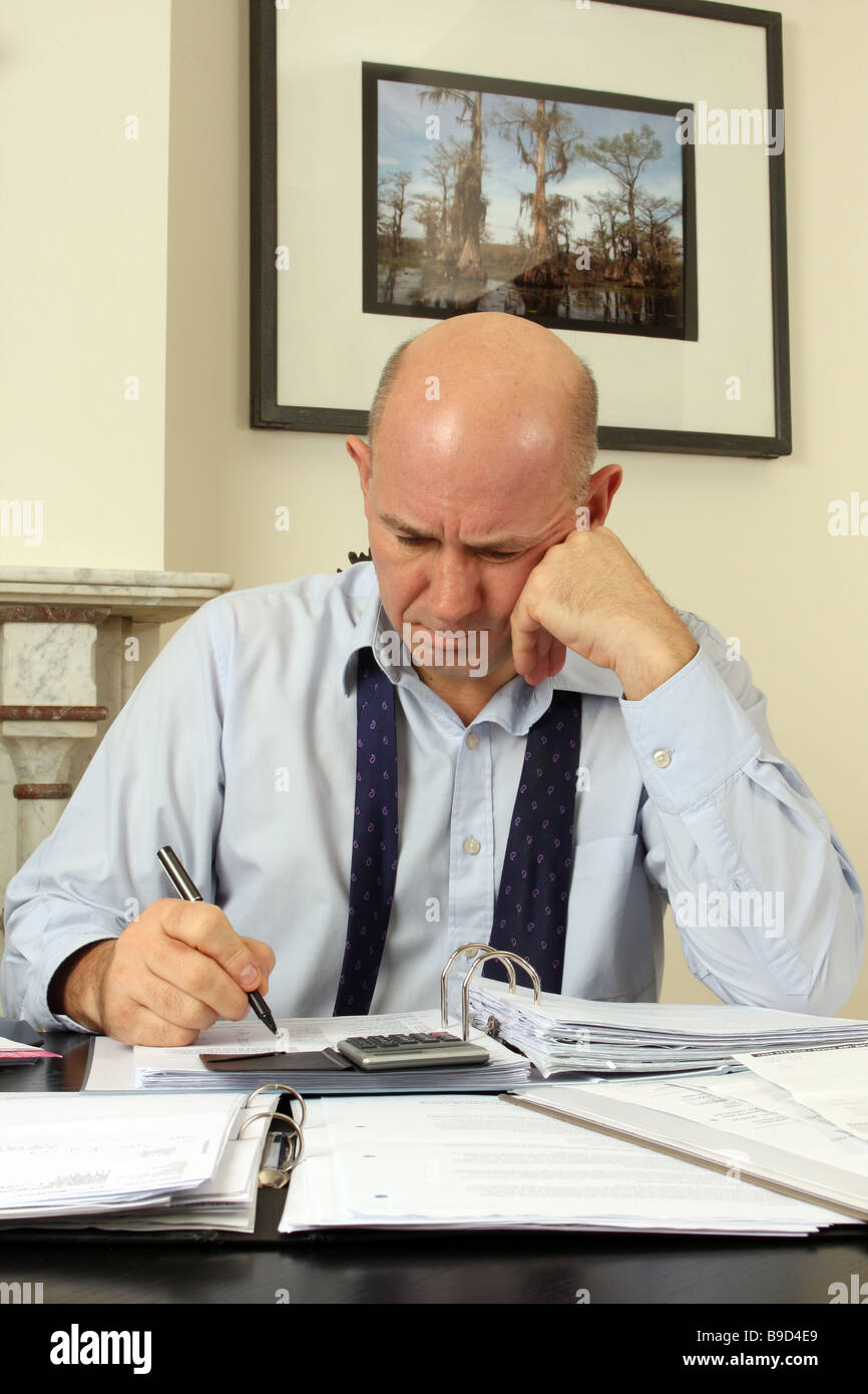 man working on his accounts and worrying about figures Stock Photo - Alamy