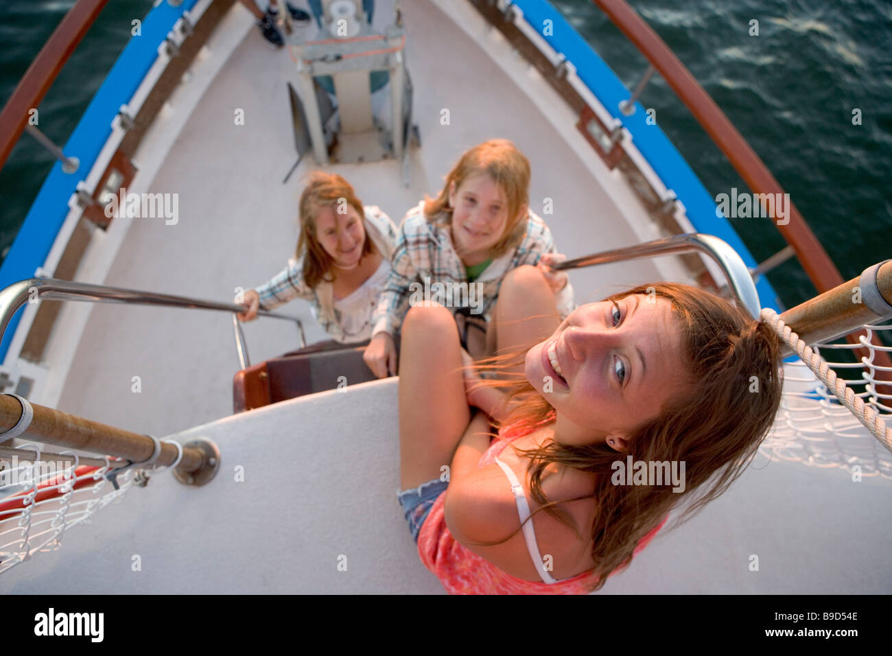 Three teen-aged girls near the bow of a tour boat at sunset Stock Photo ...