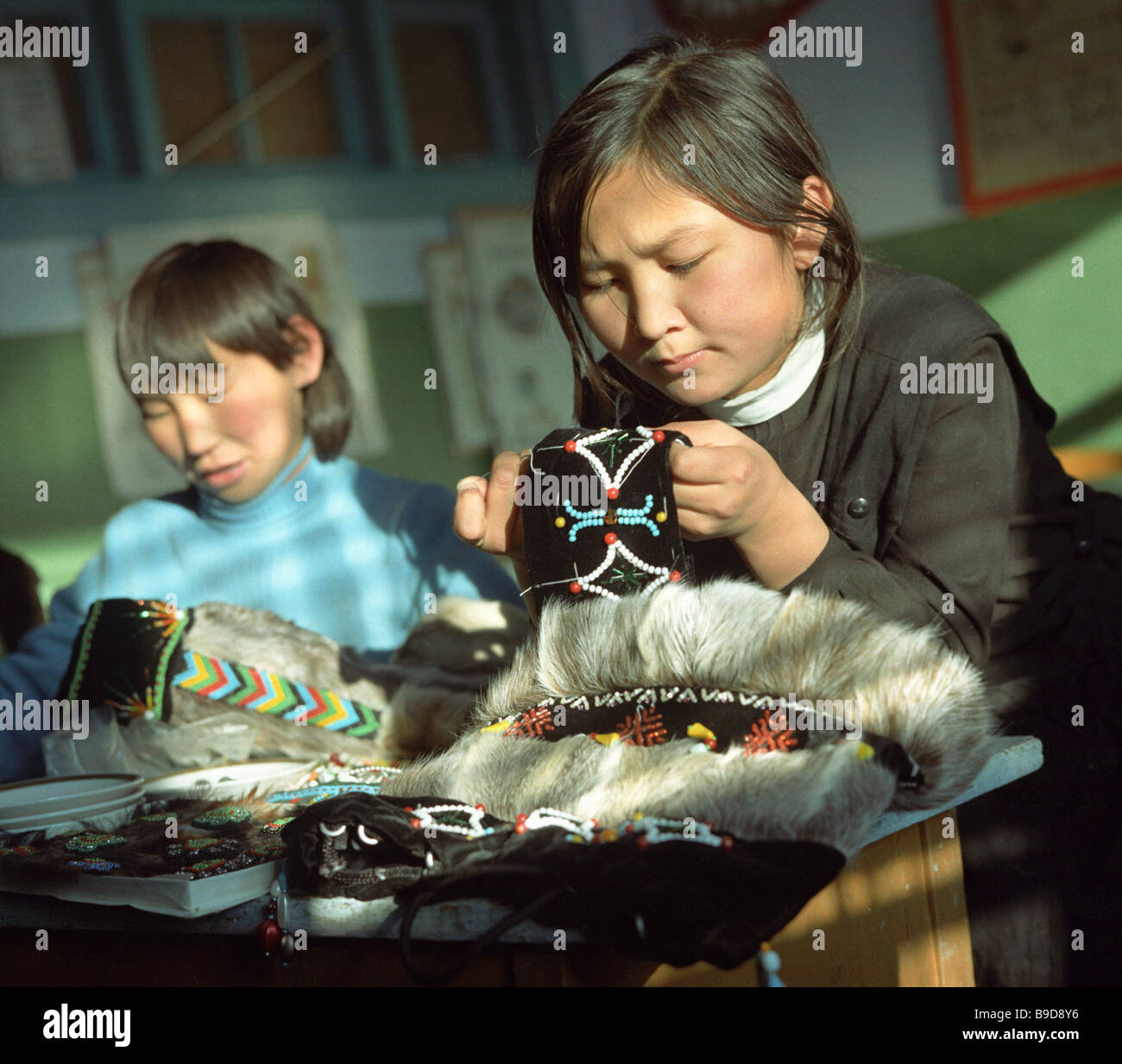 Schoolgirls making national Evenk costumes at handwork lesson Stock ...