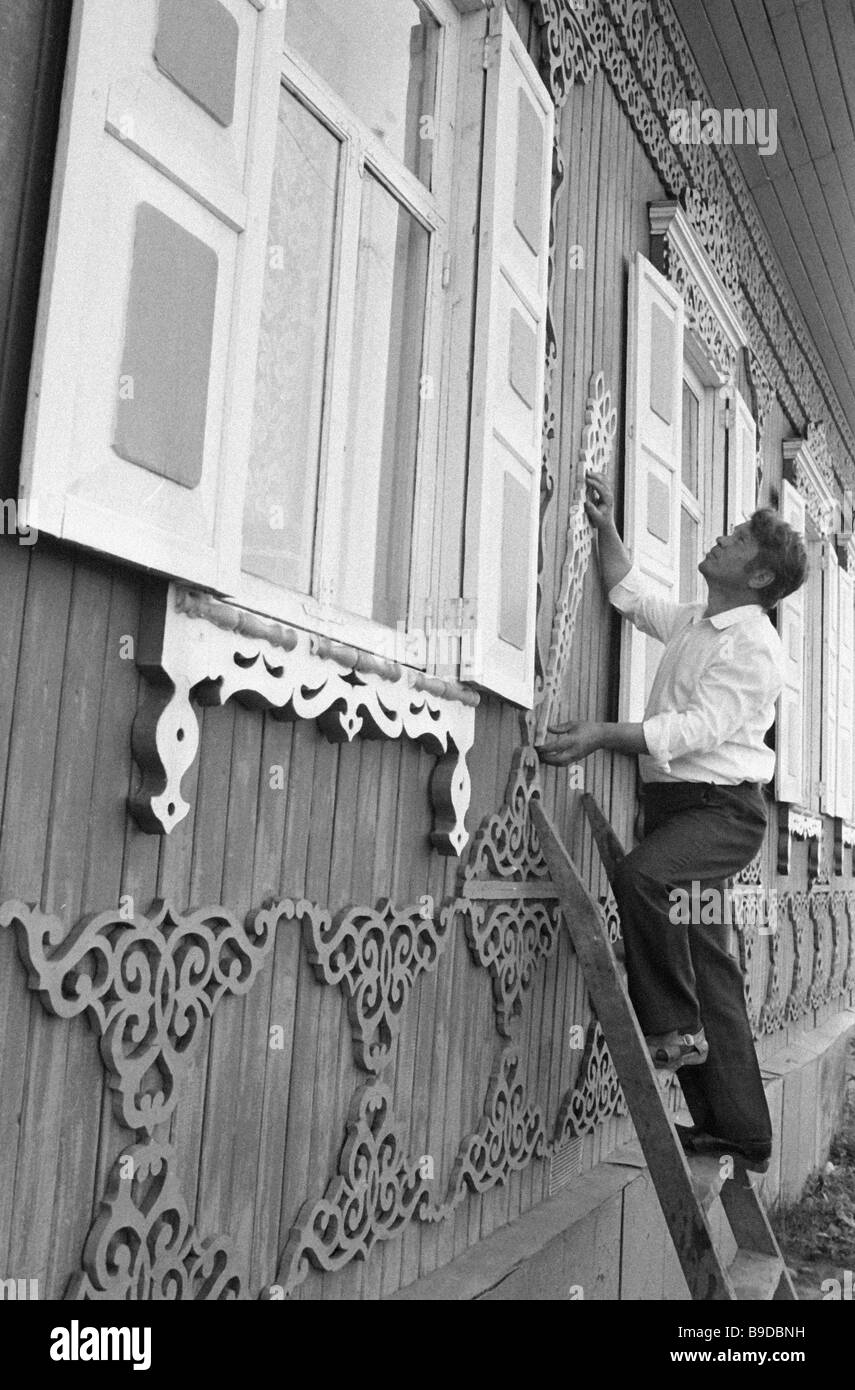 A carpenter decorating his house with woodcarving Stock Photo - Alamy