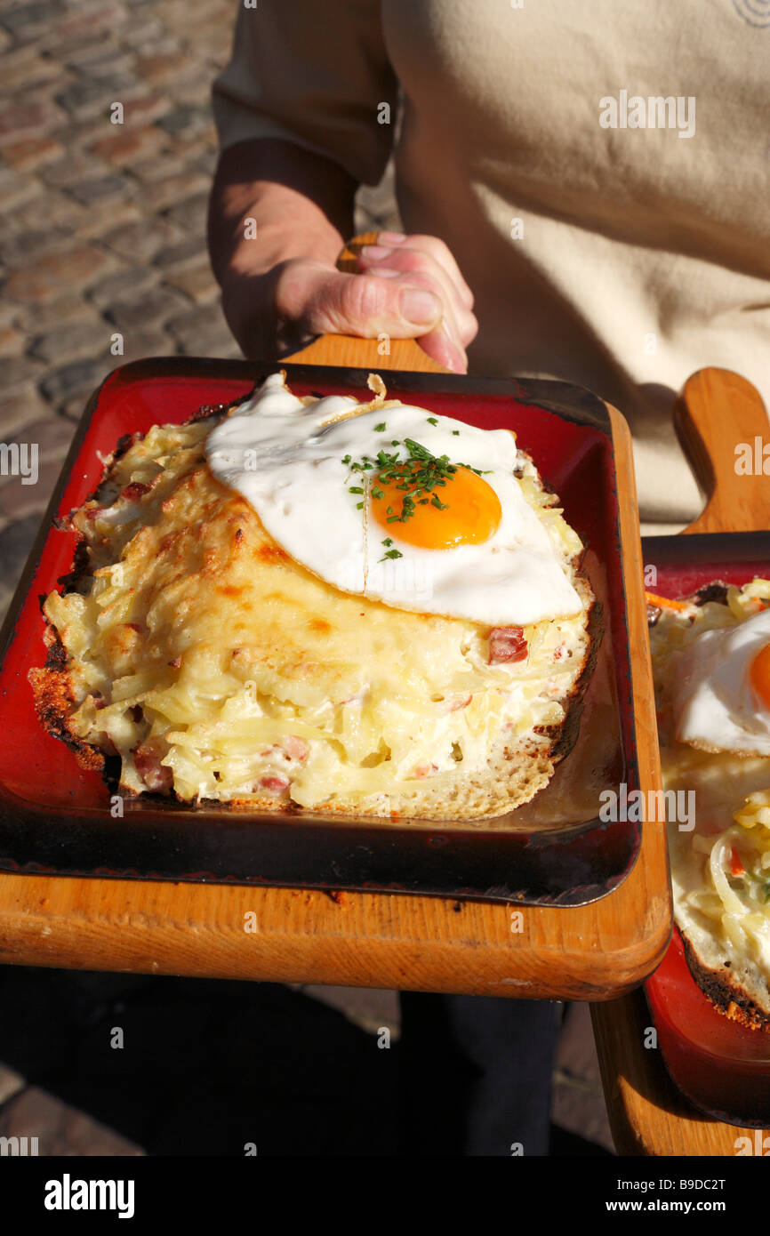Woman serving the national dish Rosti in the restaurant Hasenburg Old ...