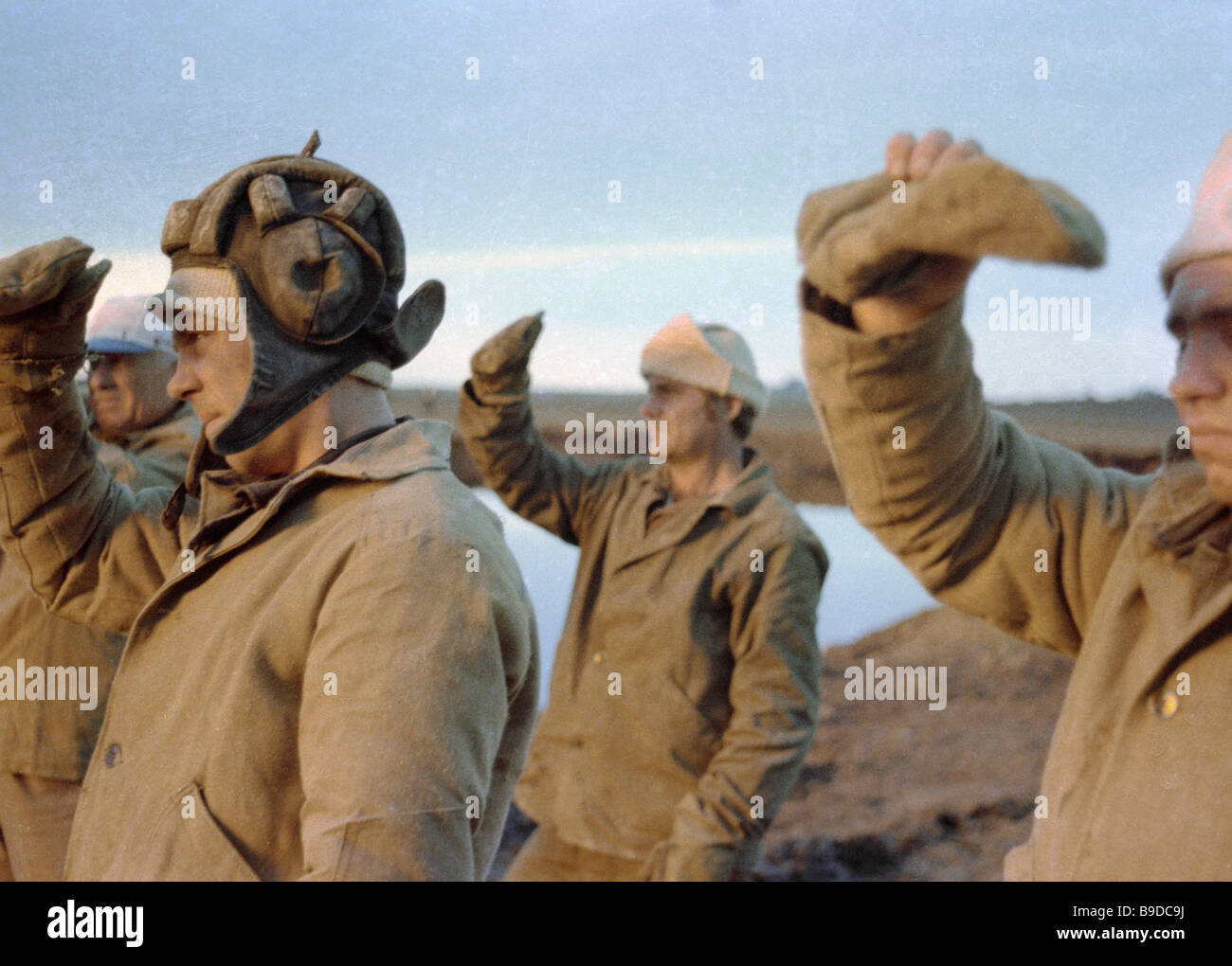 Firemen watching the extinguishing of fire by their colleagues on oil ...