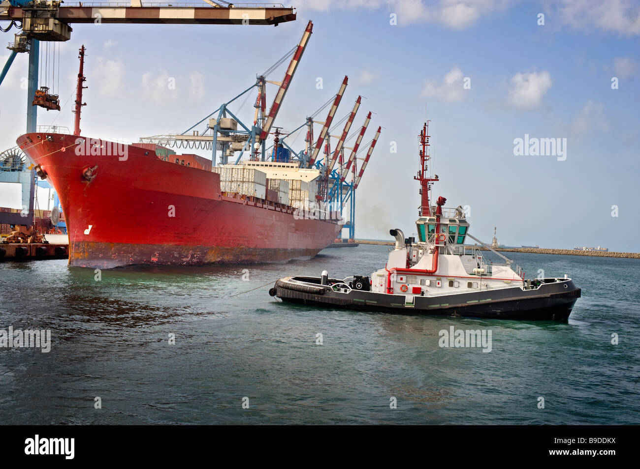 tugboat pulling a cargo ship away from the dock Stock Photo - Alamy