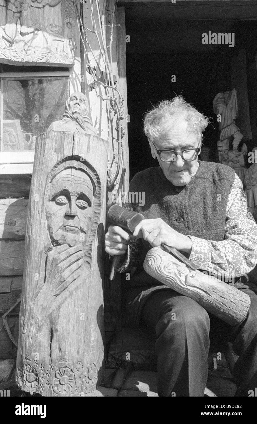 Village craftsman Appolinary Pupko carves out wooden sculpture Stock ...