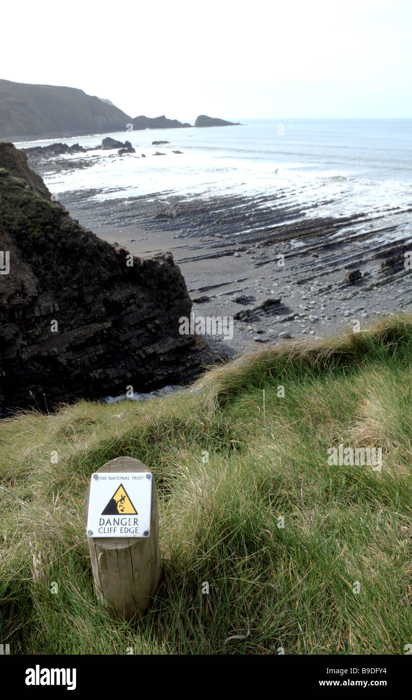 A waring sign indicating a dangerous cliff and risk of falling,with a ...