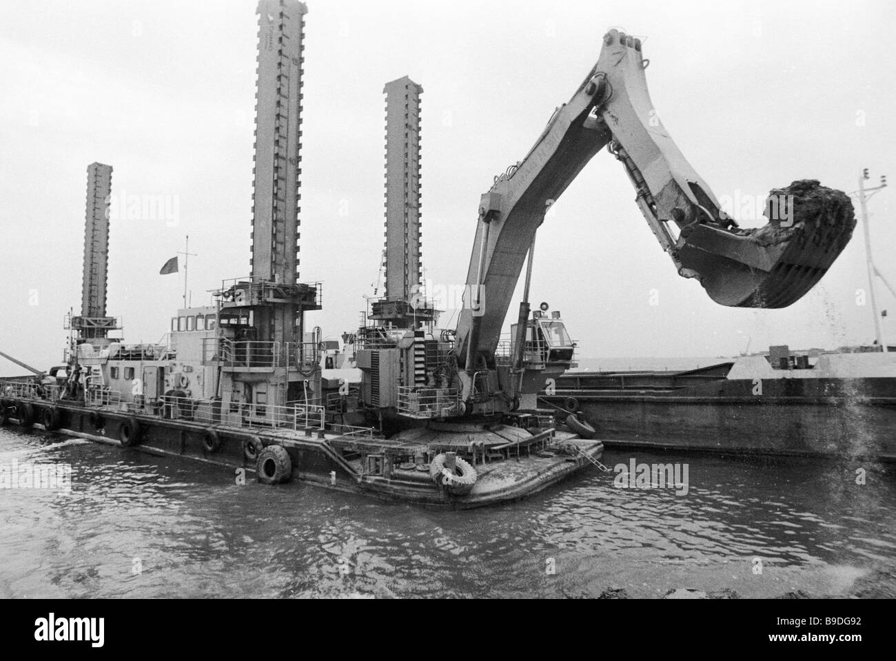 A Diesel engined floating excavator building a flood protection dike ...