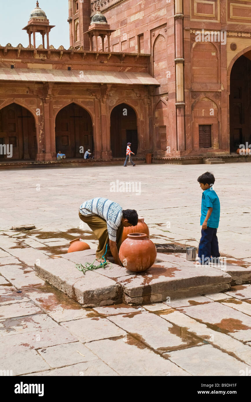 Indian man getting water in the courtyard of mosque in Fatehpur Sikri ...