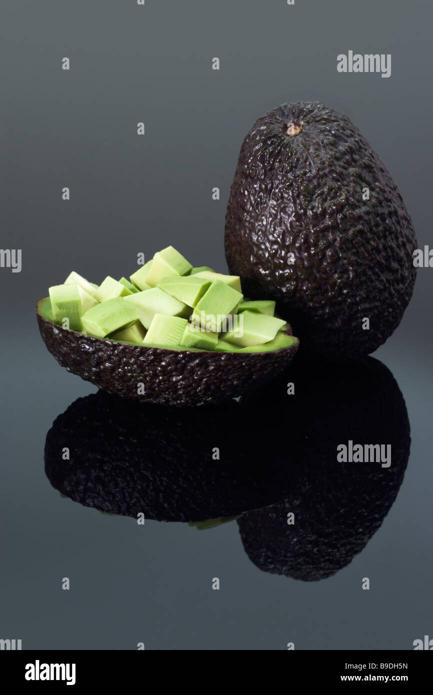 Avocados on dark reflective background Stock Photo - Alamy