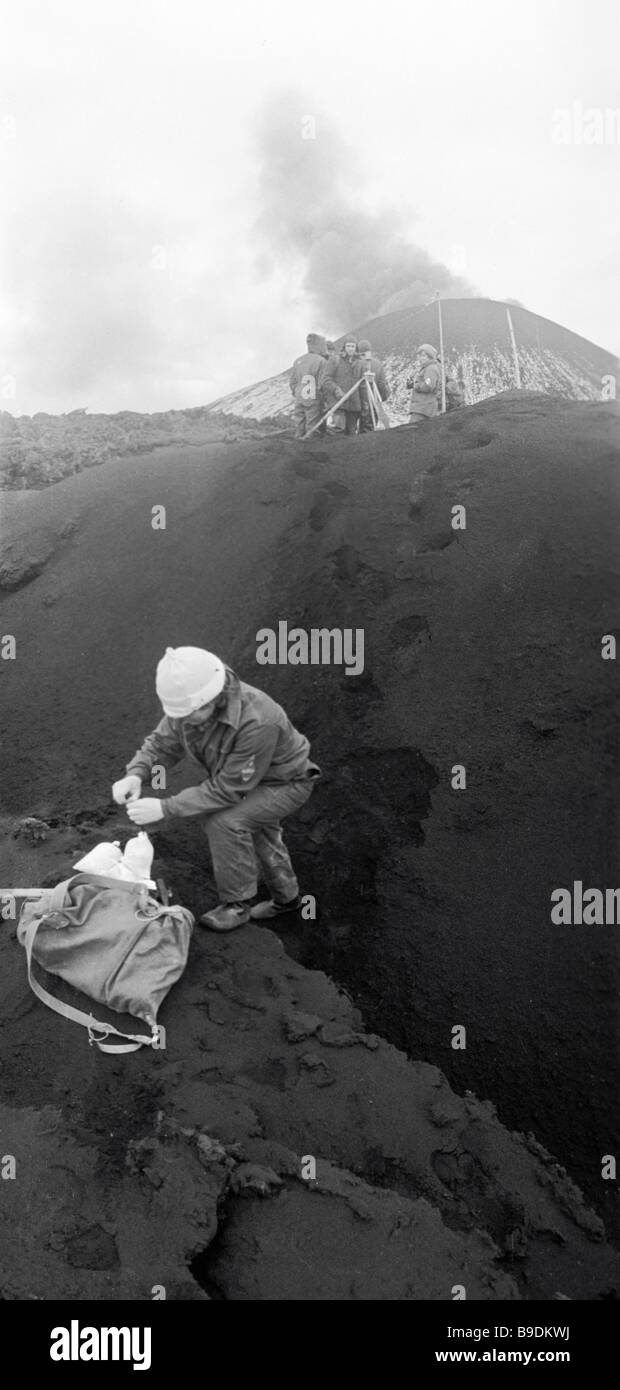A volcanologist taking ash and lava samples from the Mutnovsky Volcano ...