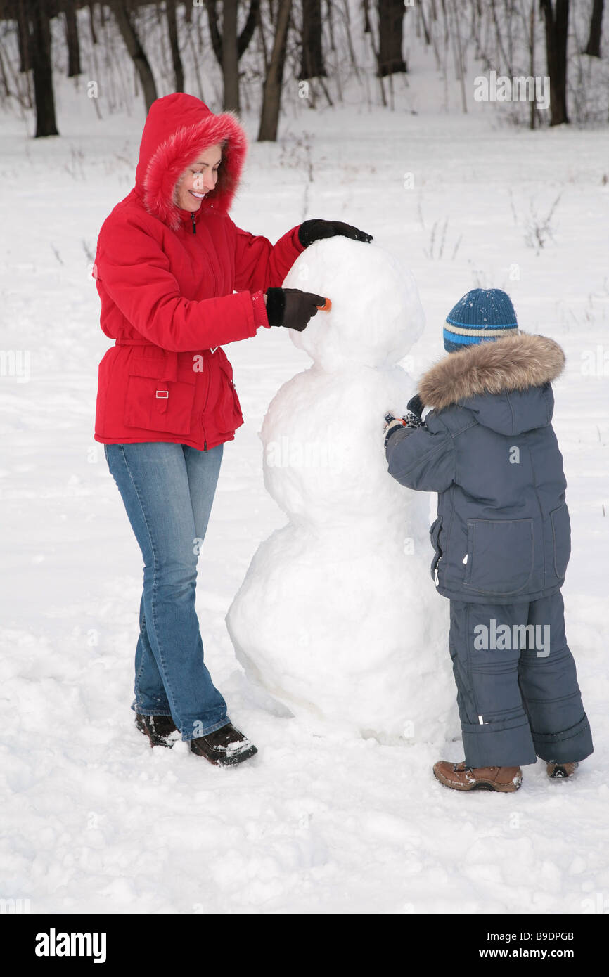mother and child make snowman Stock Photo - Alamy