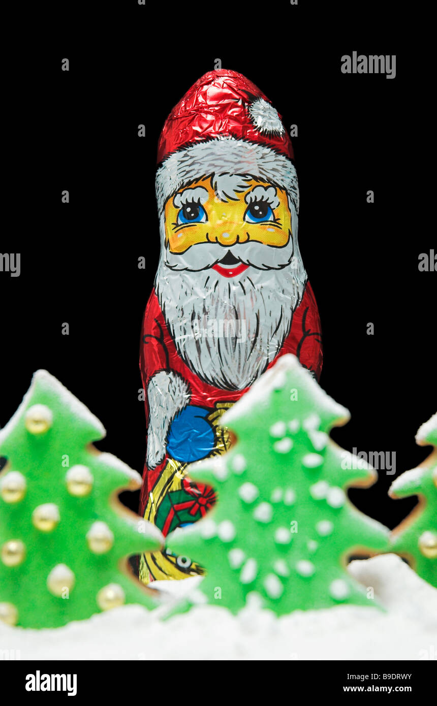 Chocolate Santa Claus and sugar cookies shaped like Christmas tree with ...