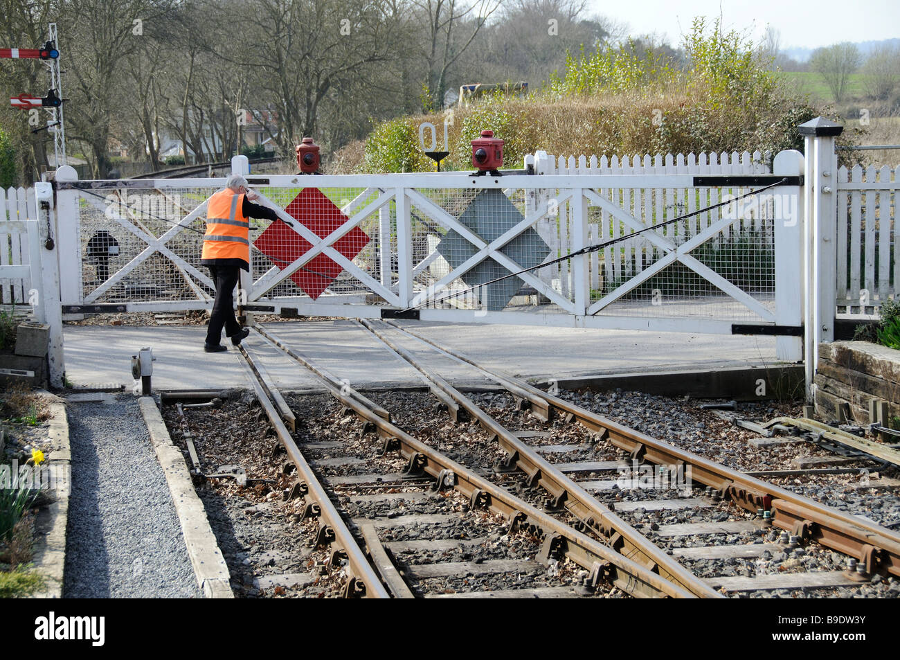 Railway worker pushing open level crossing gate of a unmanned crossing ... Railway worker pushing open level crossing gate of a unmanned crossing ...