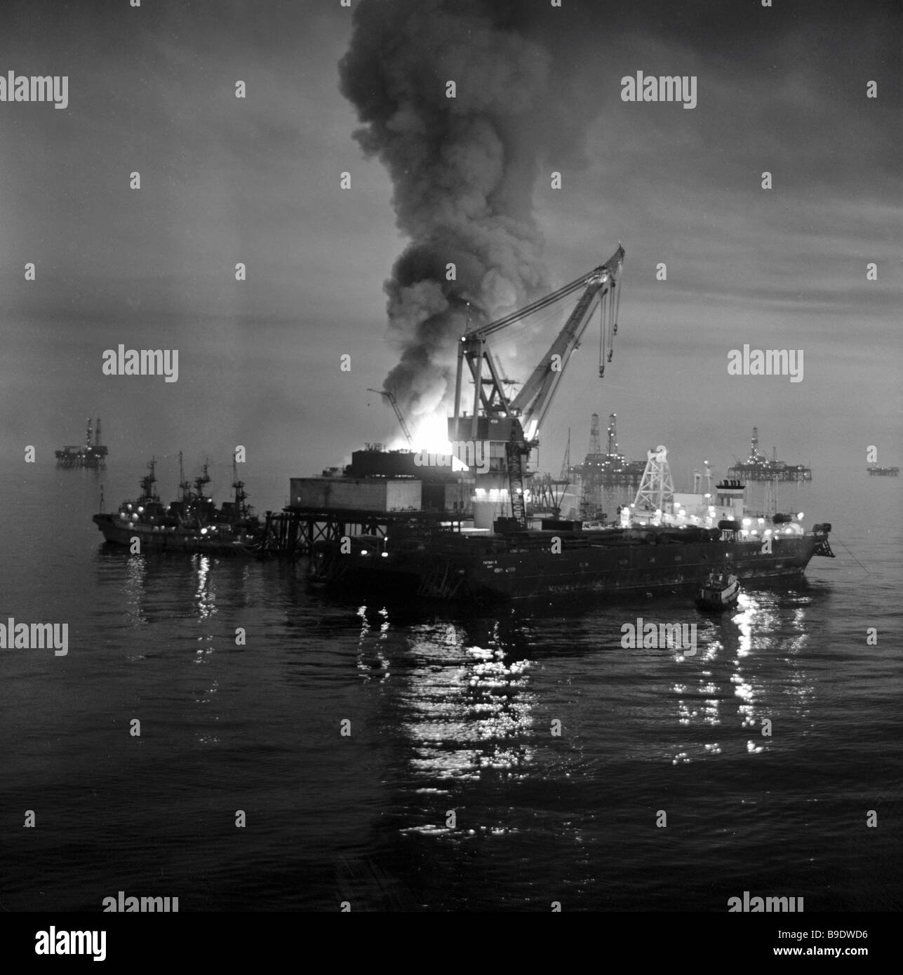 Rescue and fire fighting boats putting out the fire at the offshore oil ...