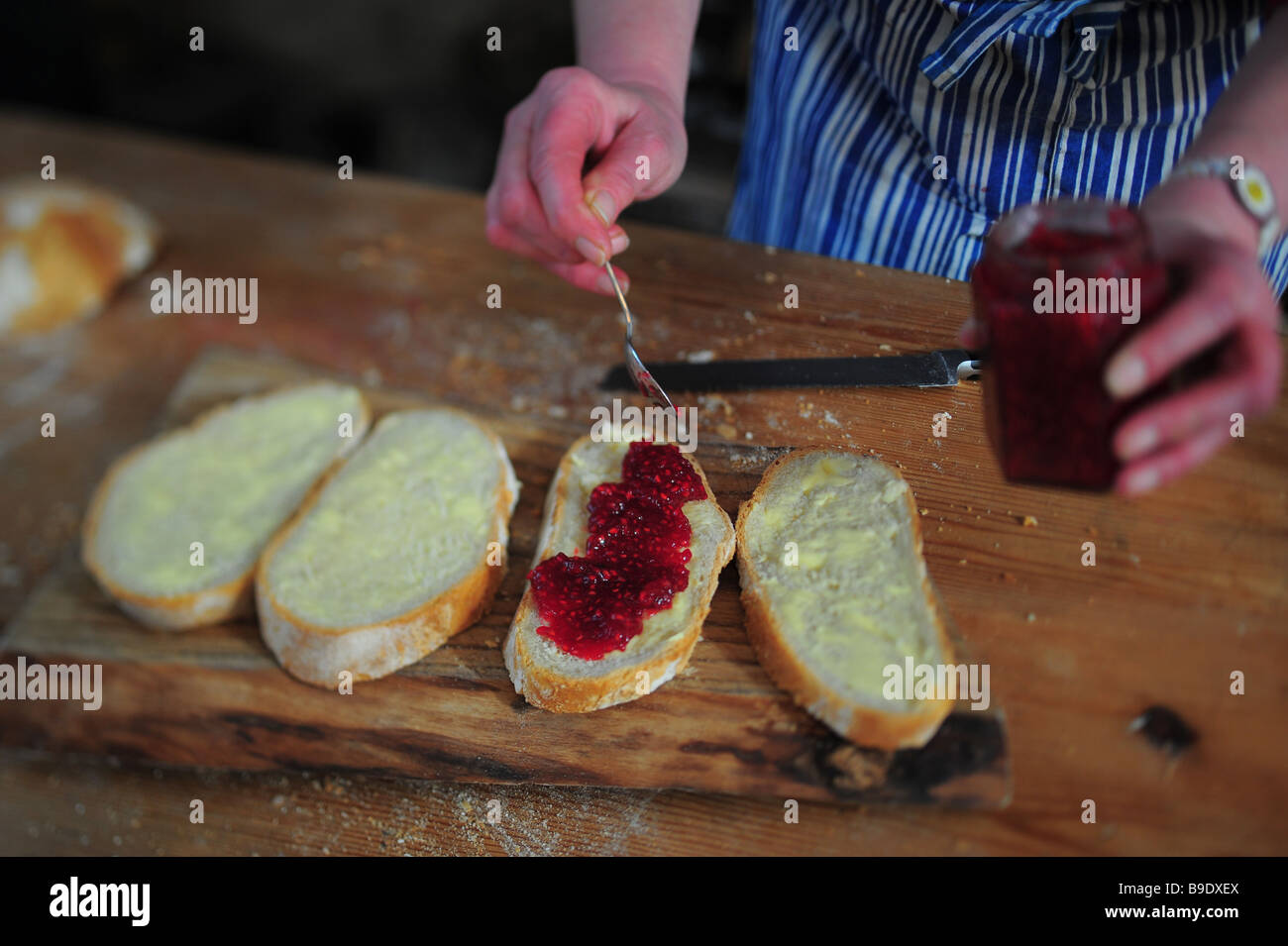 making a jam sandwich with home made jam and bread. spreading the jam ...