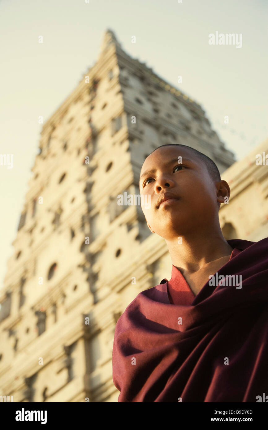 Low angle view of a monk day dreaming in front of a temple, Mahabodhi ...