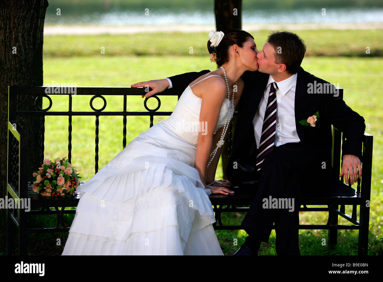 Couple kissing on park bench hi-res stock photography and images - Alamy