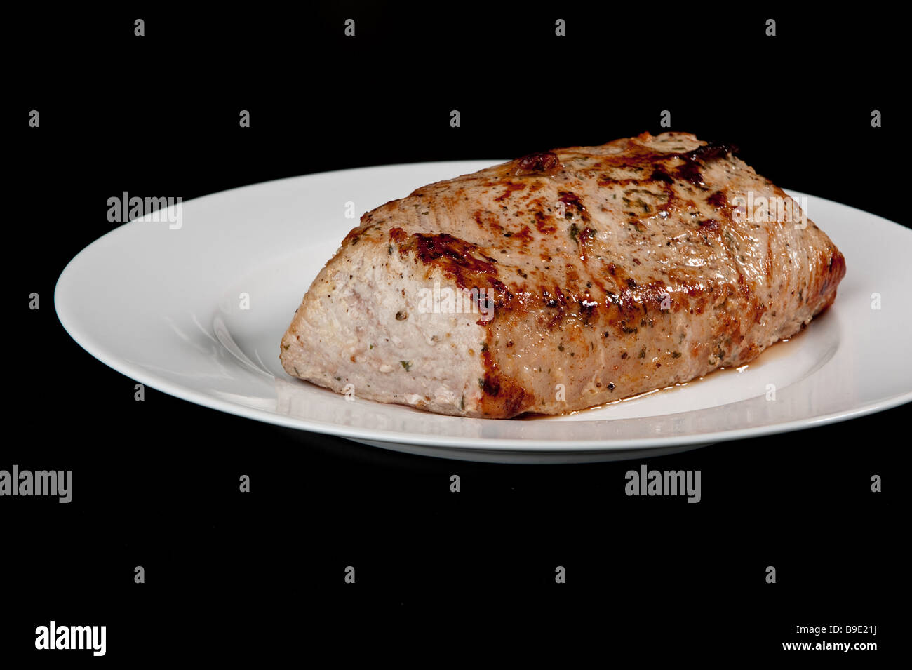Image of a freshly cooked pork loin on a plate Stock Photo - Alamy