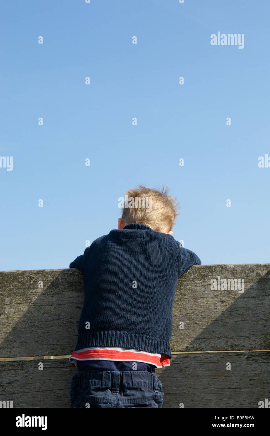 Boy climbing over wall hi-res stock photography and images - Alamy