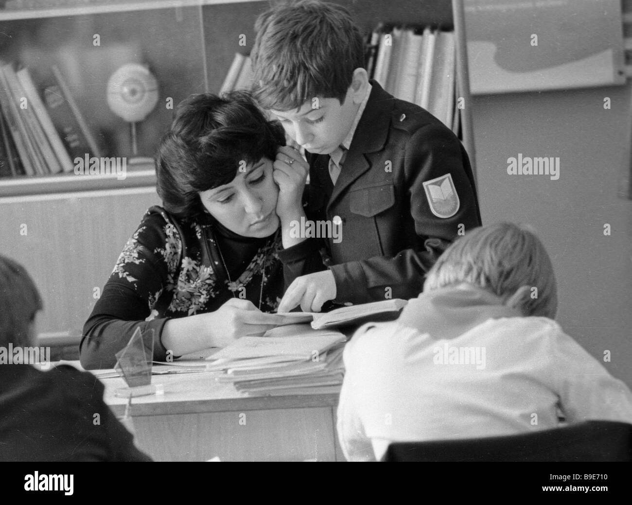 Teacher helps school student during extracurricular classes Stock Photo ...