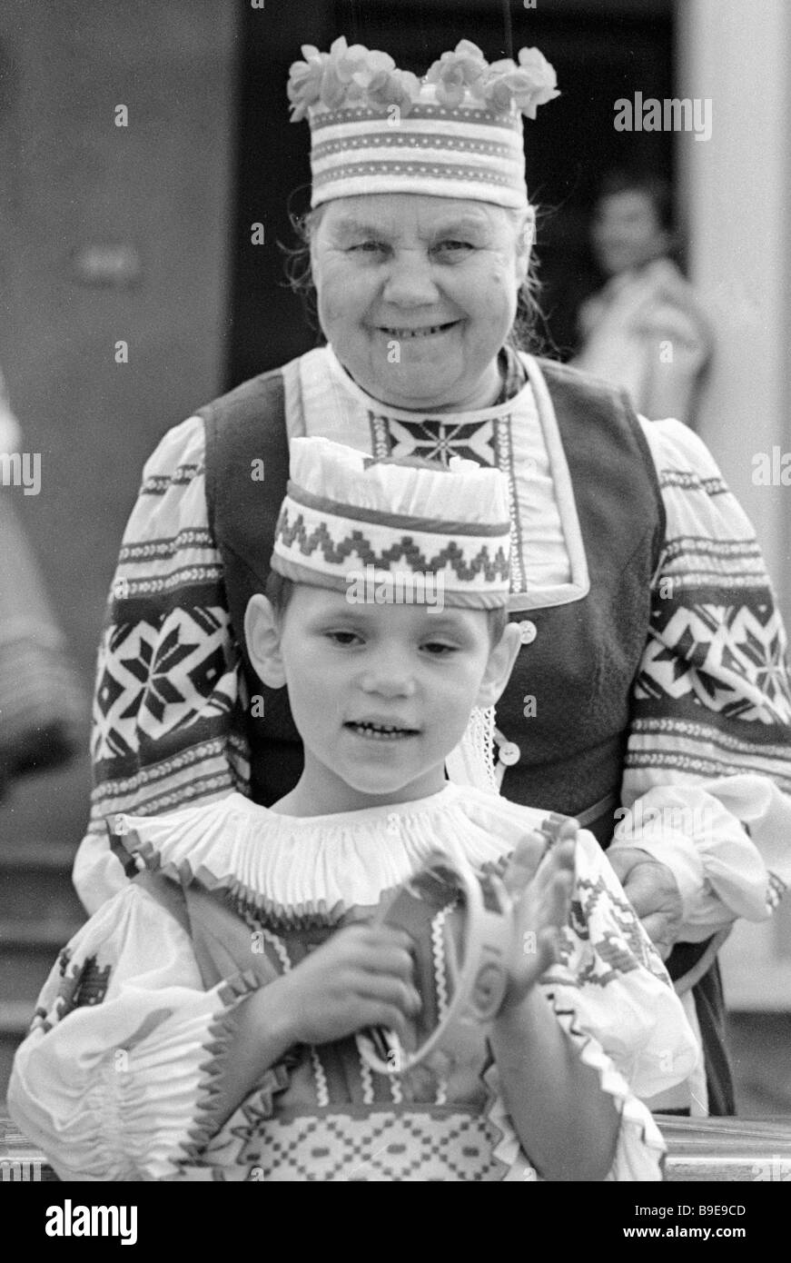 A folk ensemble member with her granddaughter in traditional Belarusian ...