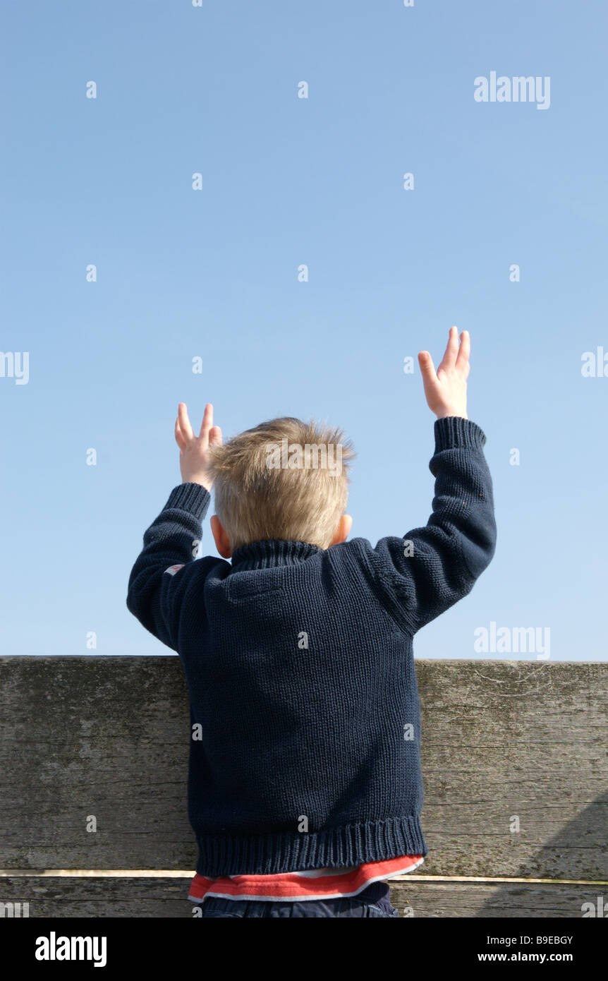 Boy looking over a wall Stock Photo - Alamy