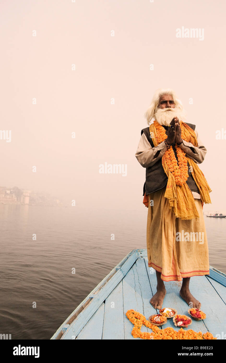 Sadhu standing on a boat and praying, Ganges River, Varanasi, Uttar ...