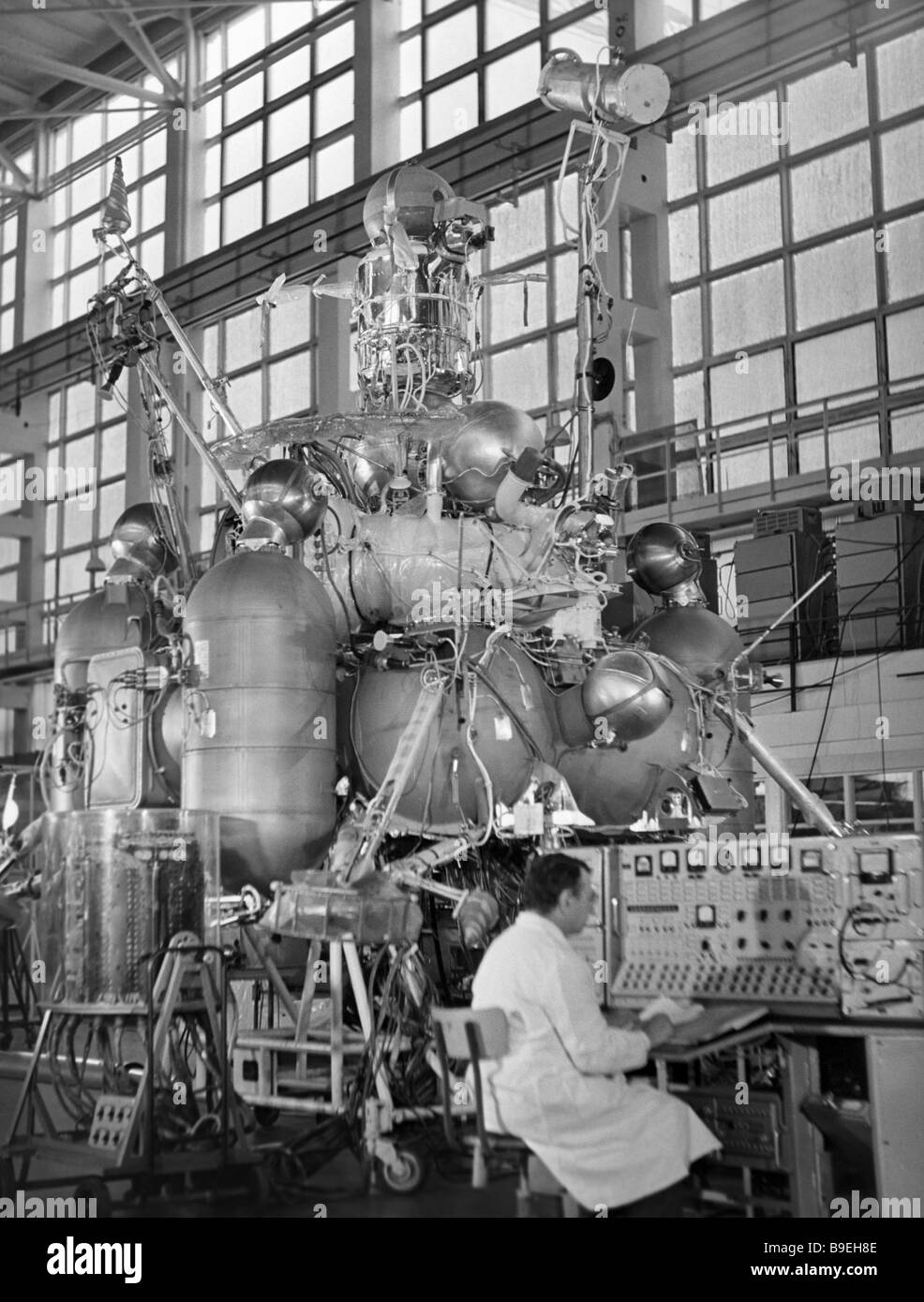 An assembly and test expert checks Luna 16 automated lunar station ...