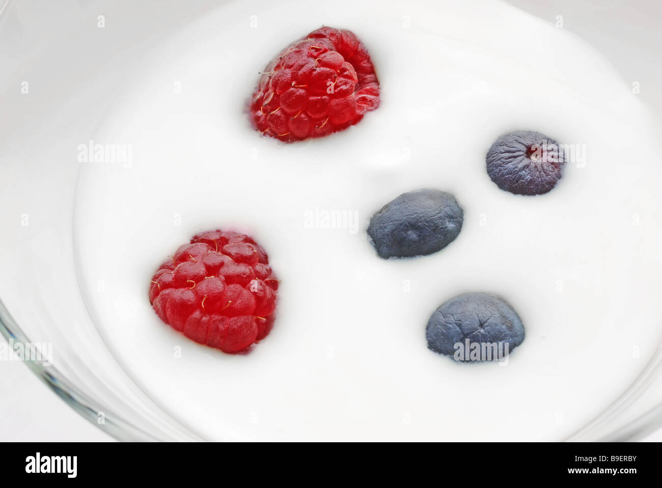 Raspberries and blueberries in yogurt Stock Photo - Alamy