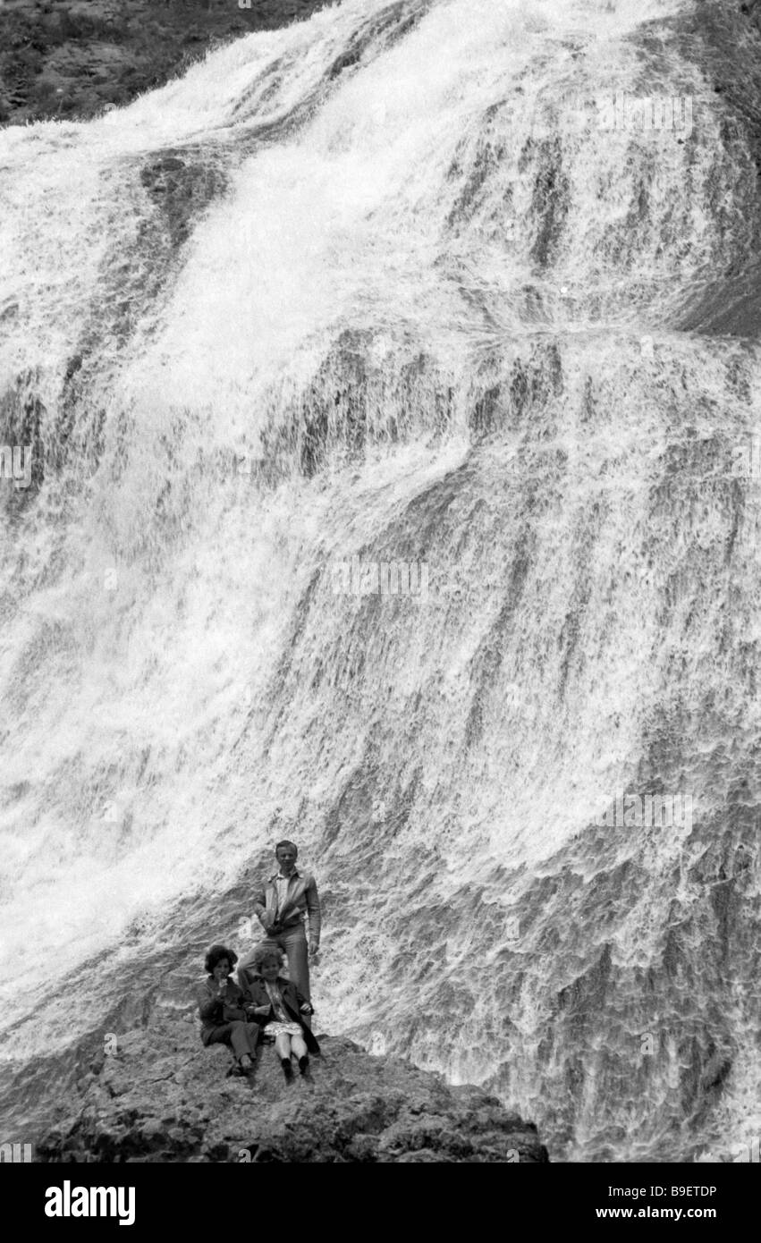 Tourists near the Dzhermuk waterfall which drops 100 meters Stock Photo ...