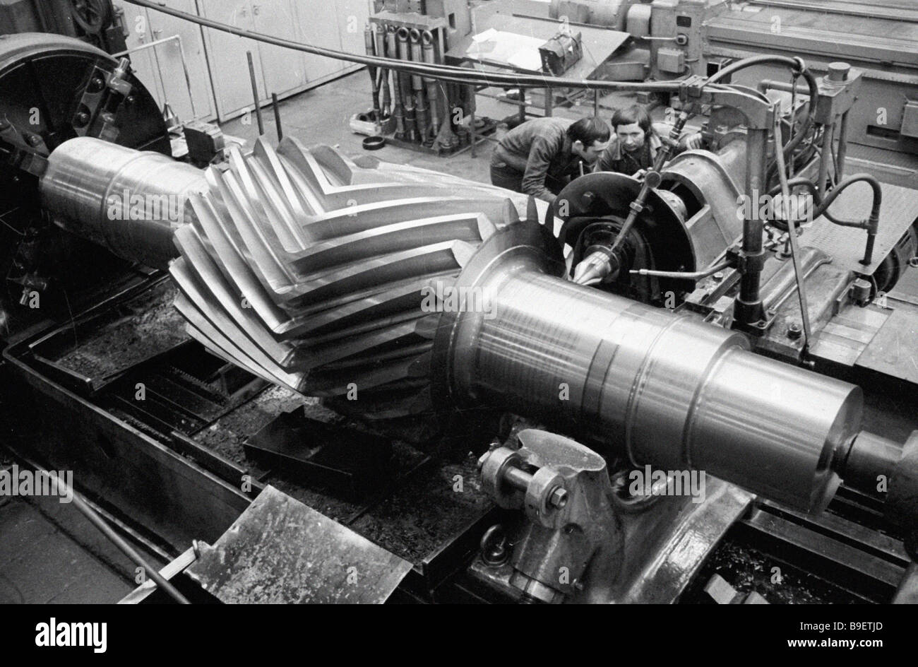 Workers tooling up an automatic machine for iron and steel production ...