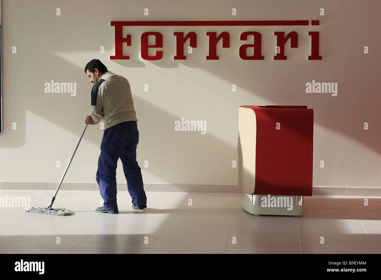 Man mopping floor in front of ferrrari logo Stock Photo - Alamy