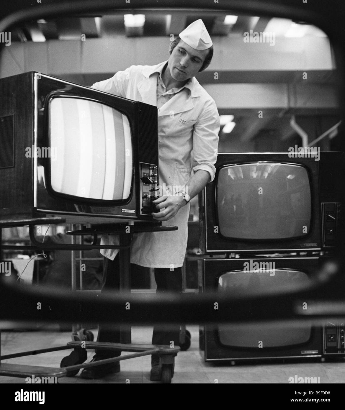 An inspector checks the quality of television sets made at the Elektron ...