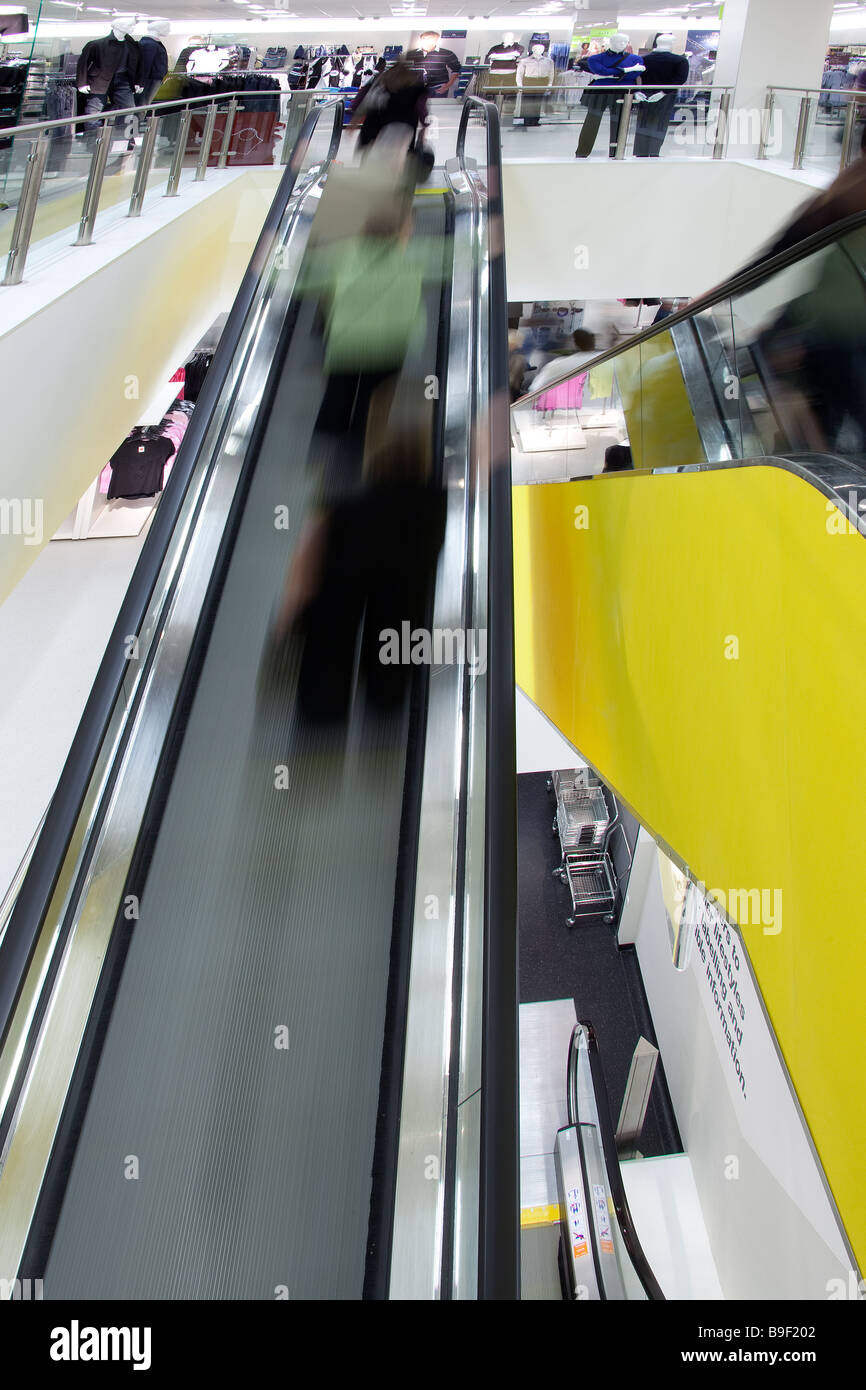 A retail shop interior showing escalator and shoppers Stock Photo - Alamy