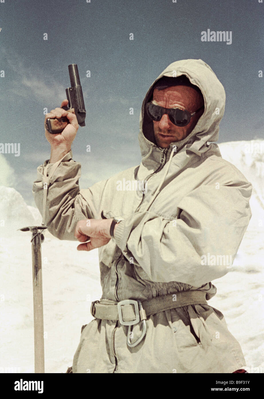 A mountaineer with a flare pistol on a mountain slope Stock Photo - Alamy