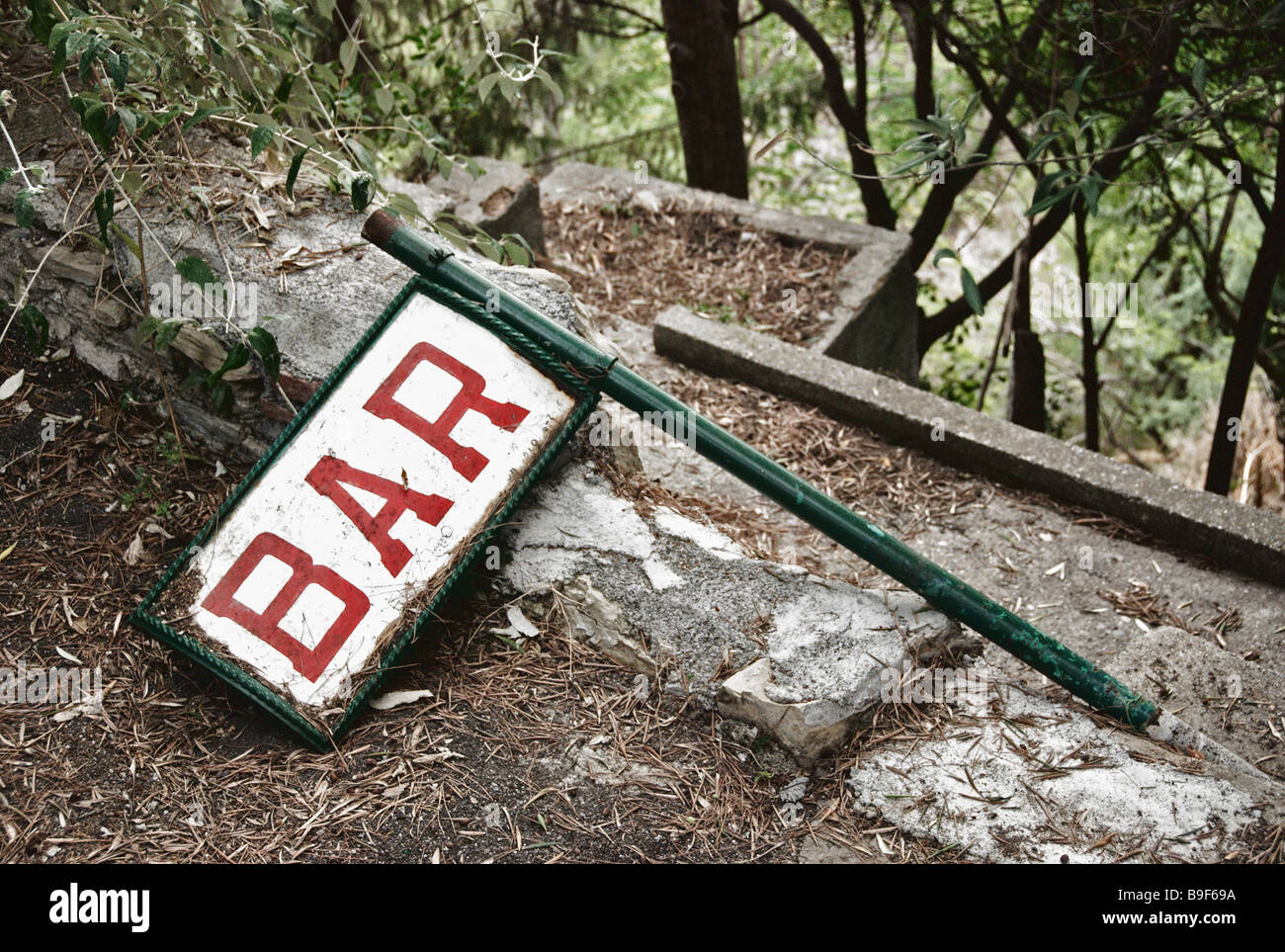 Discarded sign with the word 'bar' on it lying on a stone path in a ...