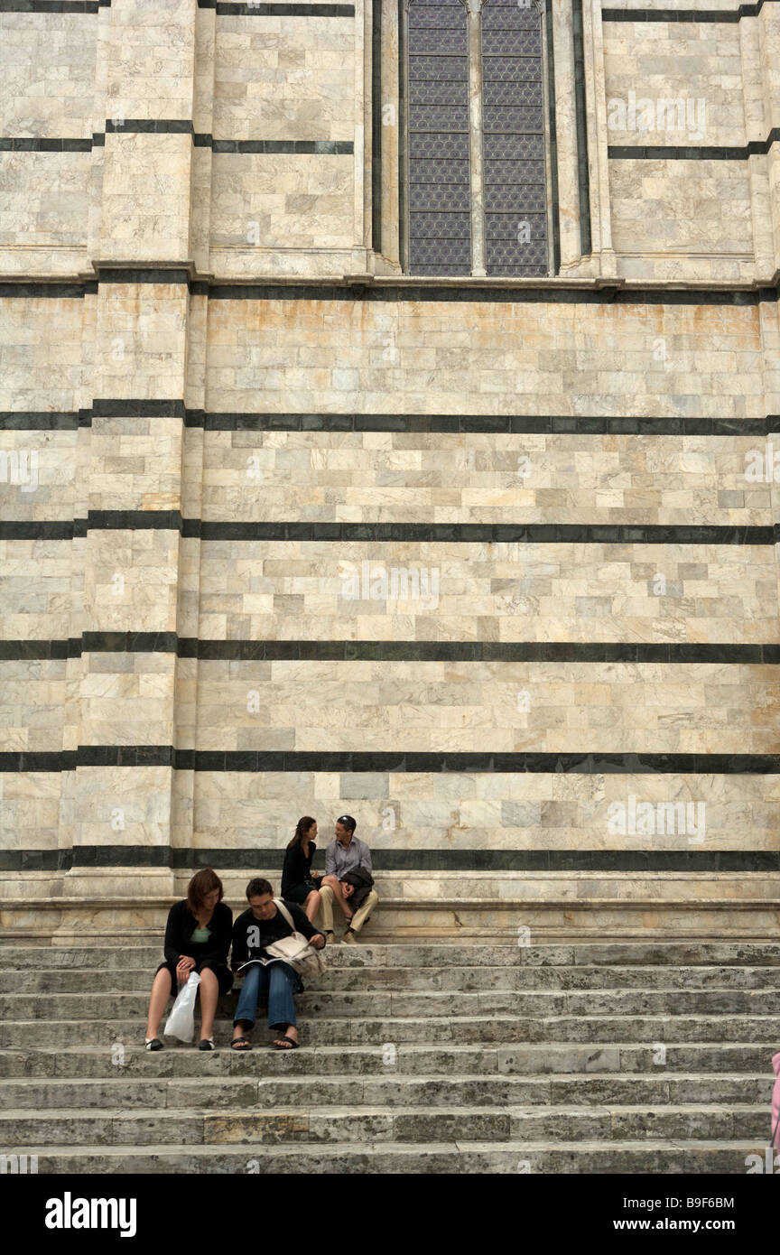 Four 4 People sit on the steps of the Duomo in Siena Italy Stock Photo ...