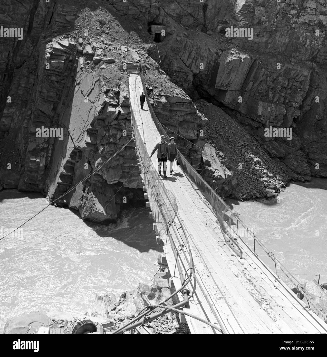 Builders of the Rogun hydropower plant cross the Vakhsh River along a ...