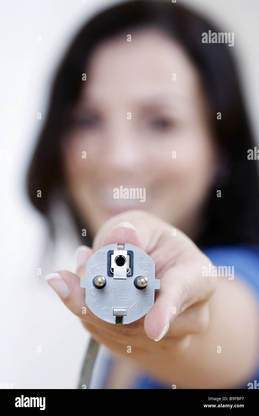 Close-up of woman's hand showing electric plug Stock Photo - Alamy