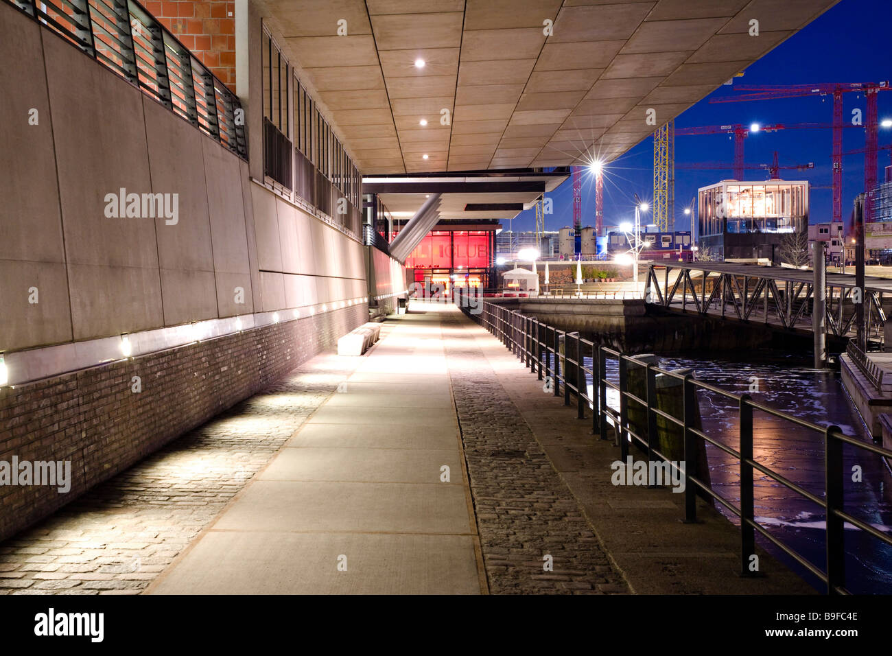 Railing along path lit up at night in city, Germany Stock Photo - Alamy
