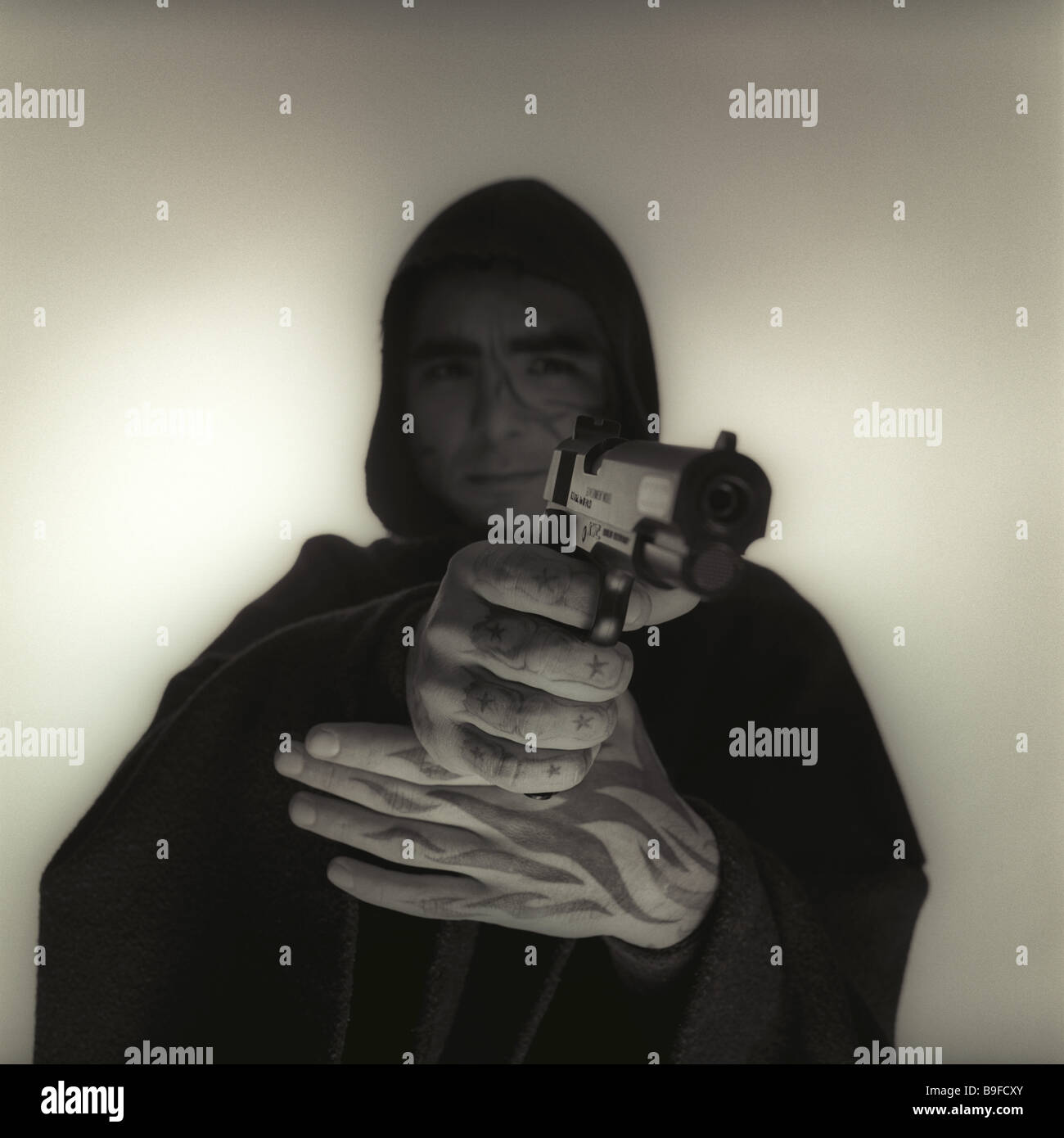 Man young "monk" seriously cowl hands tattoos aims pistol s/w crime ...