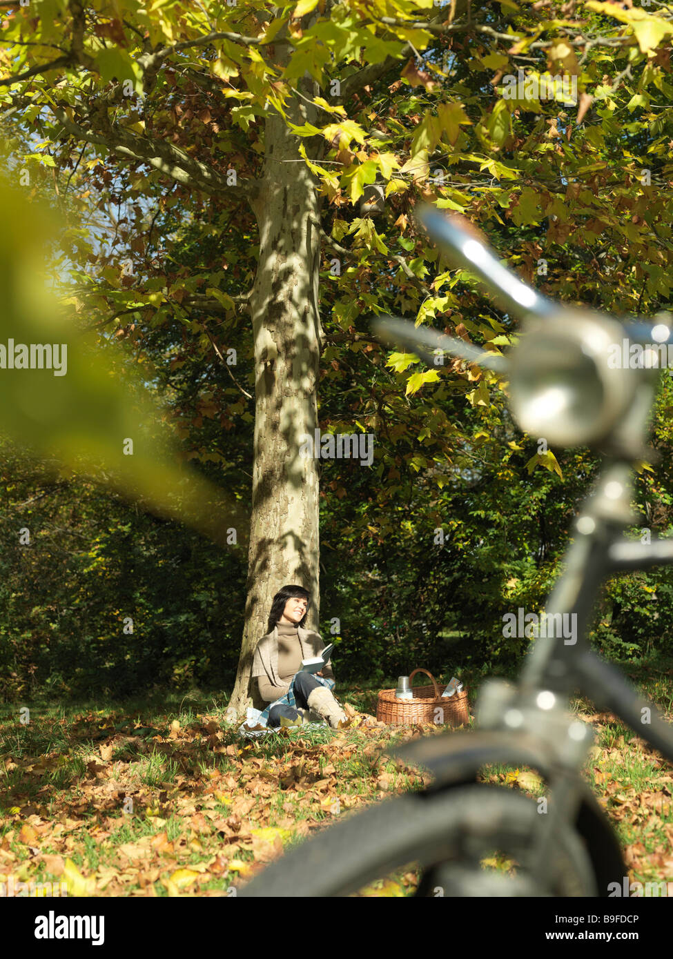 One woman sit against tree hi-res stock photography and images - Alamy
