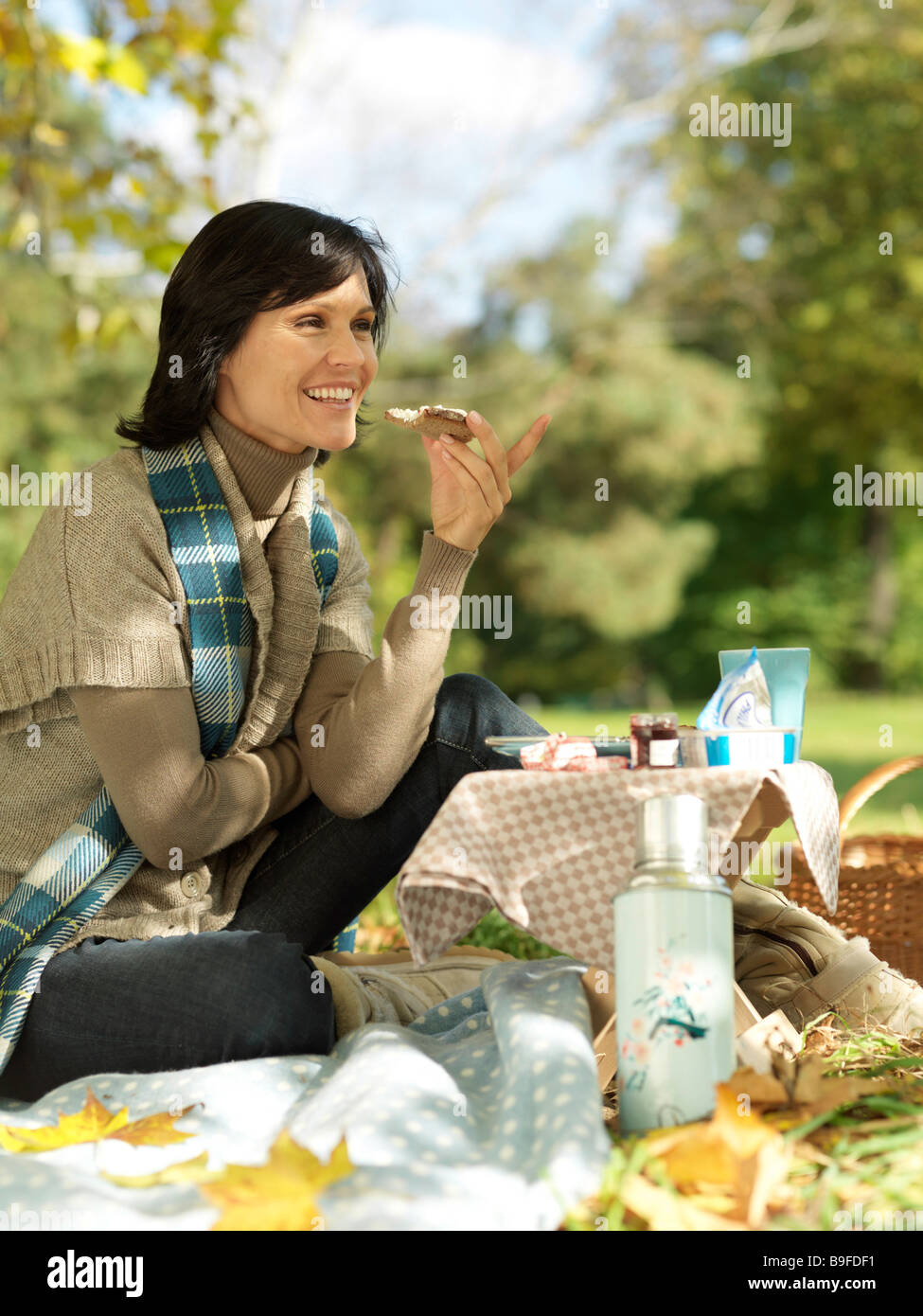 Side profile of mature woman eating a cheese slice in park Stock Photo ...