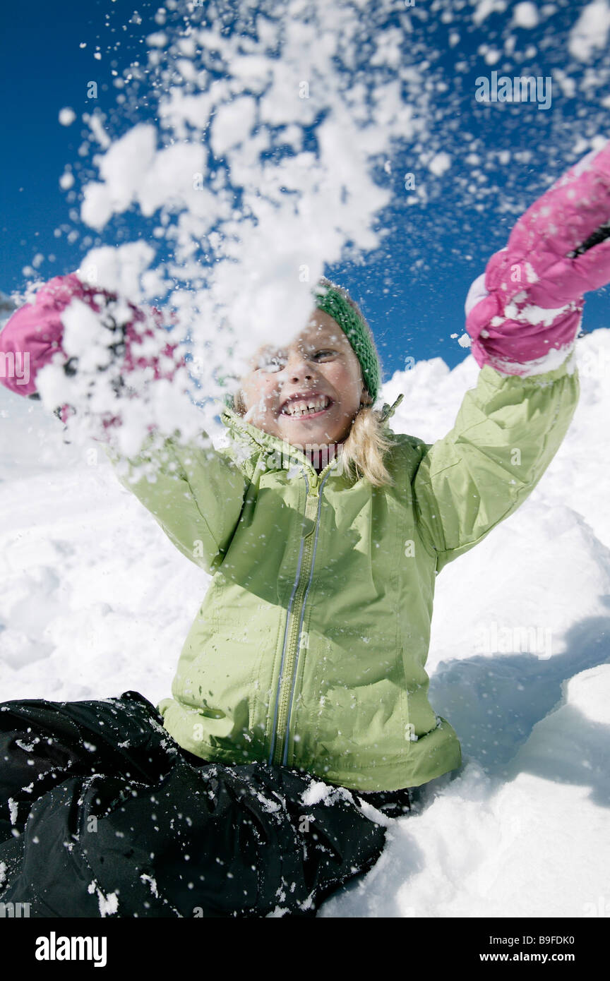 Portrait of girl throwing snow and smiling Stock Photo - Alamy