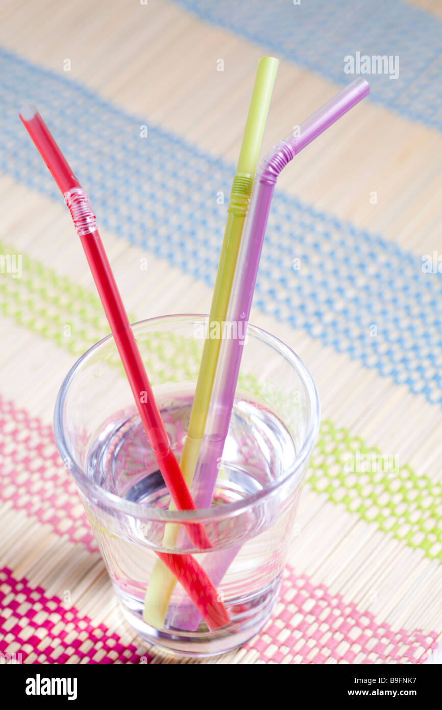 Glass of water with three straws on colorful background Stock Photo - Alamy