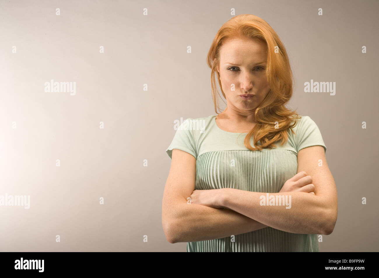 Woman red haired poor facial expression crosses displeasure fury anger ...